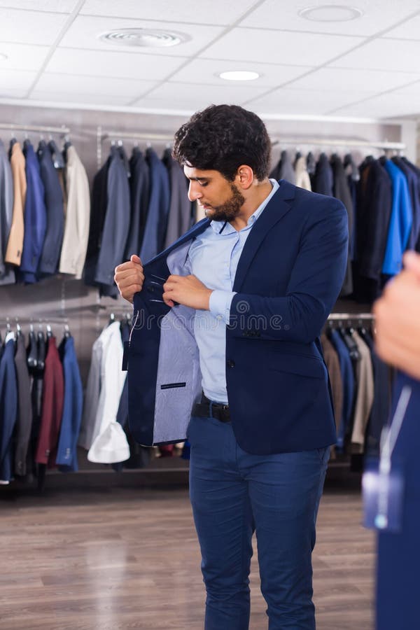 Young Customer is Trying on Jacket in Front of the Mirror Stock Photo ...