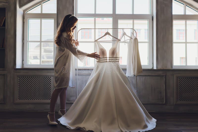 Young Cute Brunette Bride Looking at Her Wedding Dress. Stock Image ...
