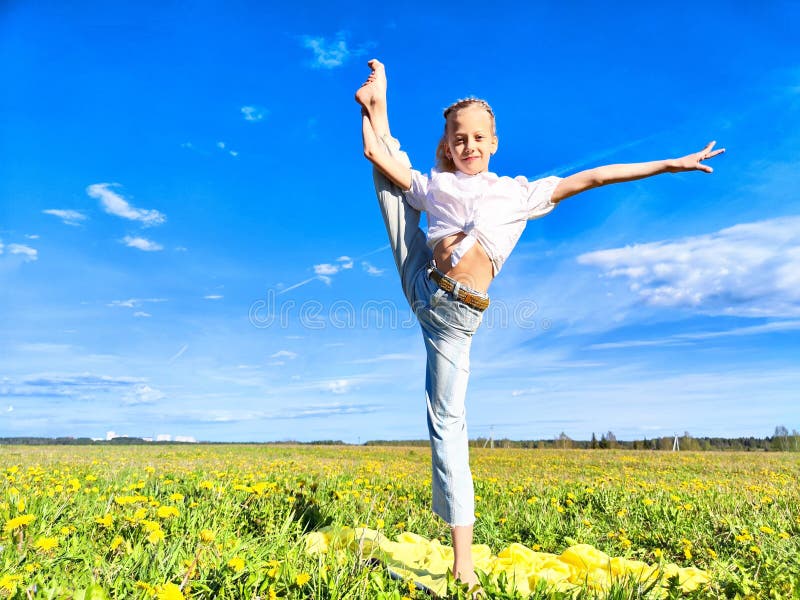 A Young Dancer Performs an Impressive Split in a Vibrant Field during a ...