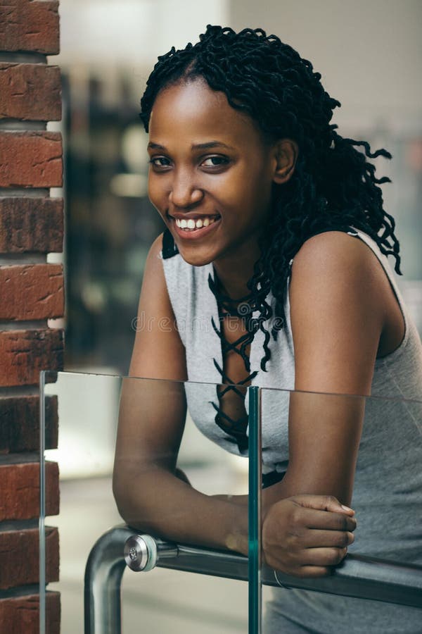 Young Dark Skinned Woman Dressed In Casual Clothes On The Bench In The
