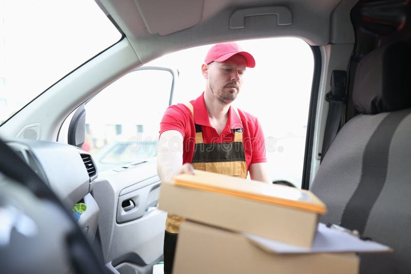 Young Delivery Man is Loading Boxes into Car Stock Photo - Image of ...