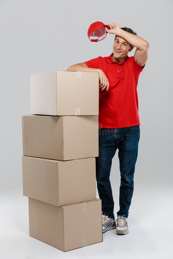 Young Delivery Man Wiping His Forehead while Posing with Cardboard ...