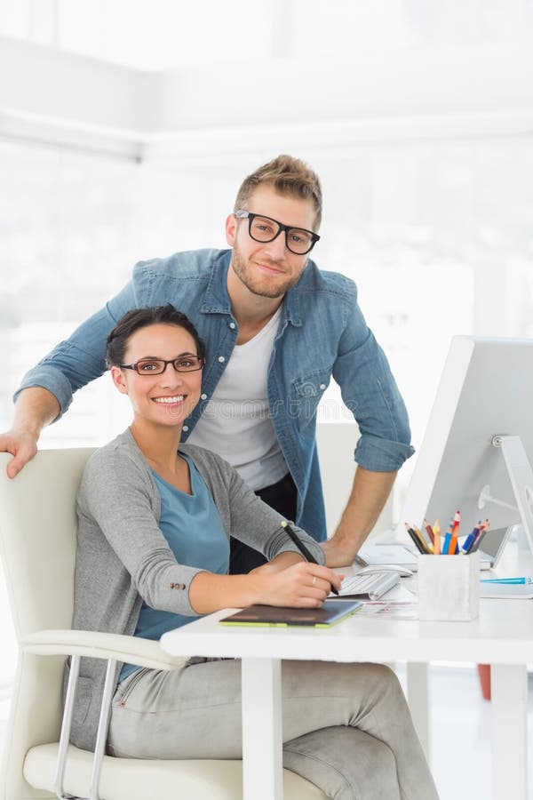 Young Design Team Working at Desk Smiling at Camera Stock Image - Image ...