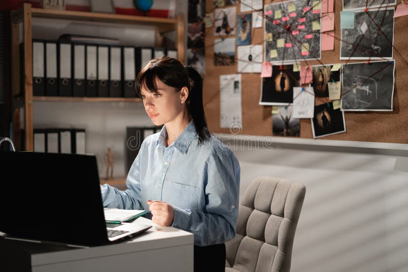 Young Detective Working in Her Office Using Laptop and Internet, Murder ...