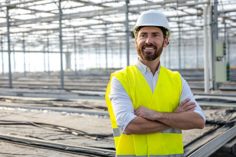 Young Determined Engineer in Yellow Protective Vest in a Greenhouse ...