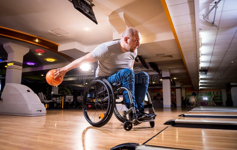 Young Disabled Man in Wheelchair Playing Bowling in the Club Stock ...