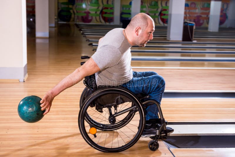 Young Disabled Man in Wheelchair Playing Bowling in the Club Stock ...