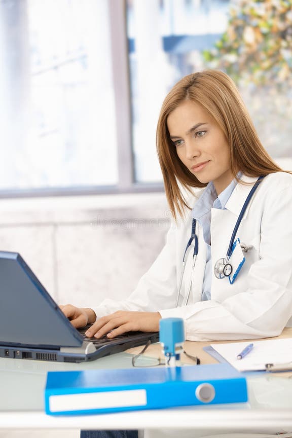 Young Doctor Browsing Internet in Office Stock Image - Image of coat ...