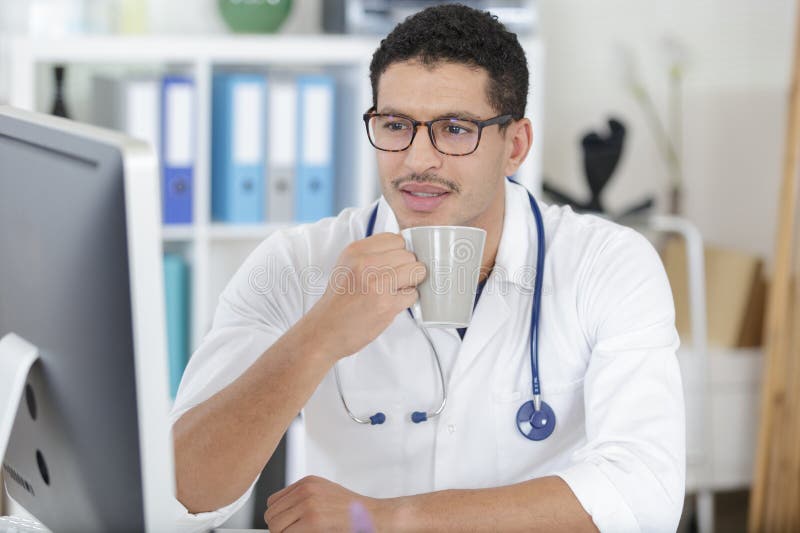 Young Doctor with Coffee Cup in Medical Office Stock Image - Image of ...