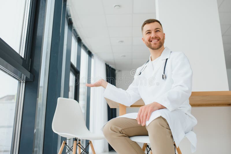 Young Doctor Sitting in His Office Behind a Desk Stock Photo - Image of ...