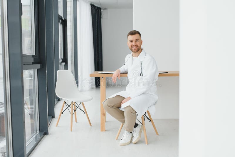 Young Doctor Sitting in His Office Behind a Desk. Stock Image - Image ...