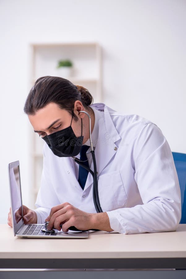 Young Male Doctor with Stethoscope Repairing Computer Stock Image ...