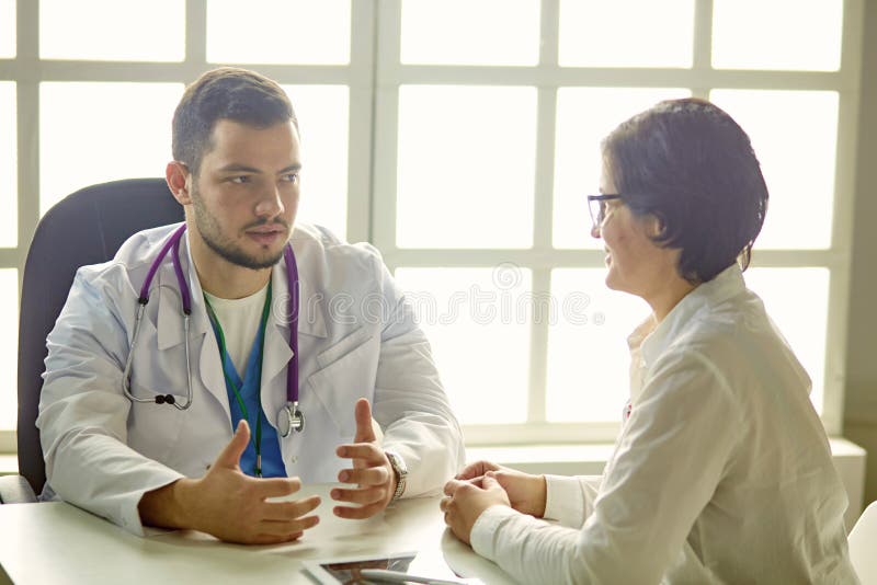 Young Doctor Talking To a Patient in the Office Stock Photo - Image of ...