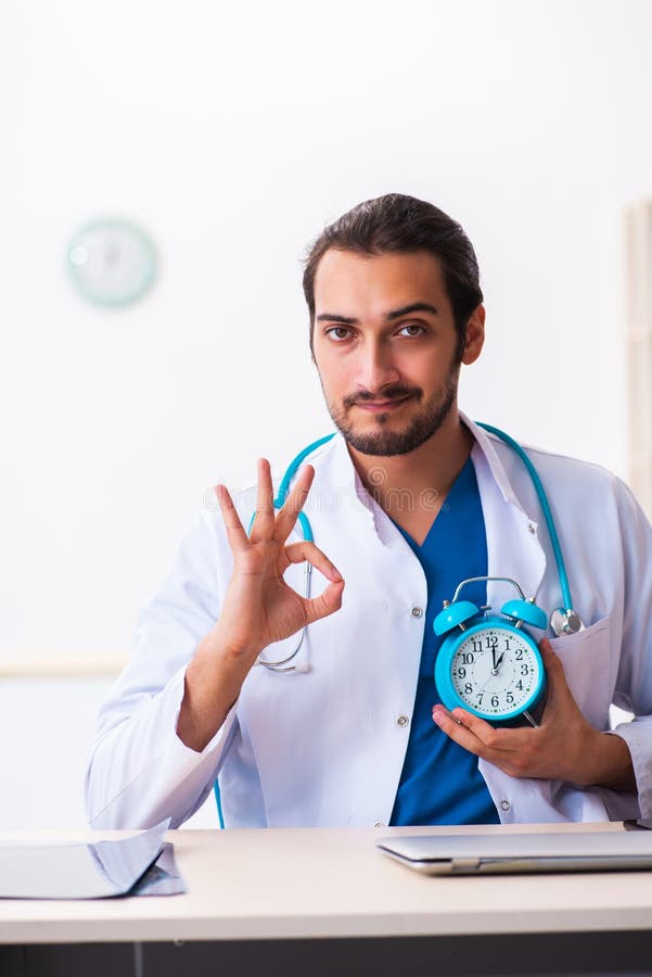Young Male Doctor in Time Management Concept Stock Photo - Image of ...