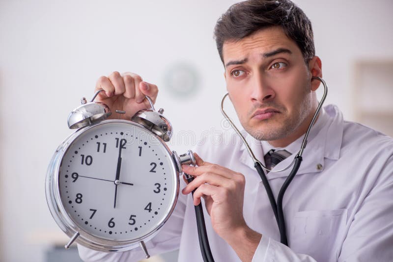 Young Male Doctor in Time Management Concept Stock Photo - Image of ...
