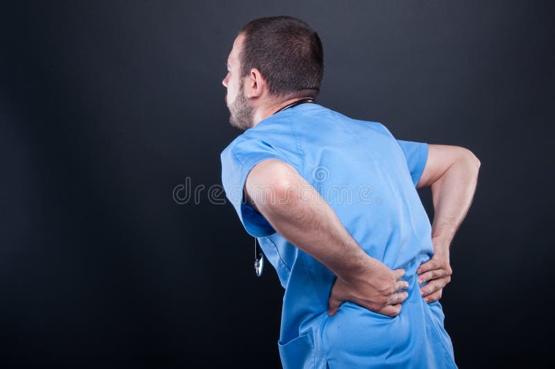 Young Doctor Wearing Scrubs Having Back Problem Stock Photo - Image of ...