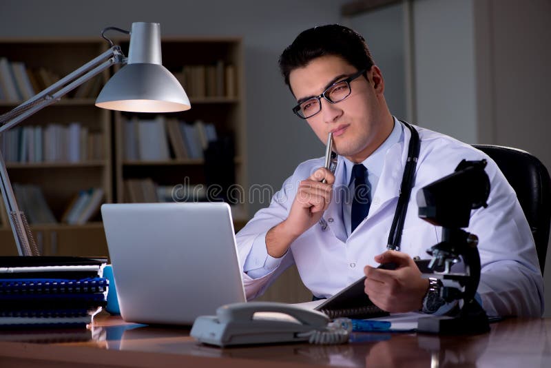 The Young Doctor Working Late in the Office Stock Photo - Image of ...