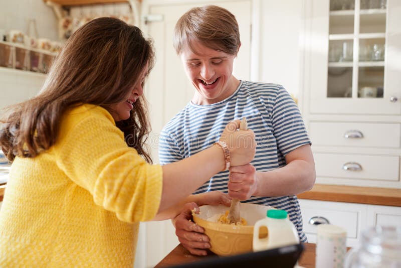 Young Downs Syndrome Couple Decorating Homemade Cupcakes With