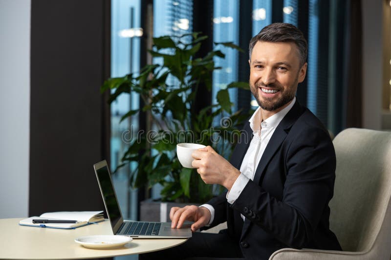 Young Elegant Businessman Working in the Office and Having Coffee Stock ...