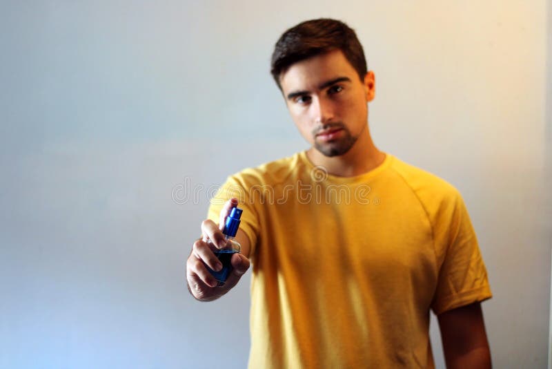 Young and Elegant Man Holding a Bottle of Blue Perfume Stock Photo ...