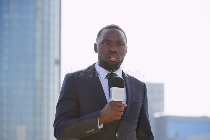 Young Elegant Reporter of African Ethnicity Speaking in Microphone in ...