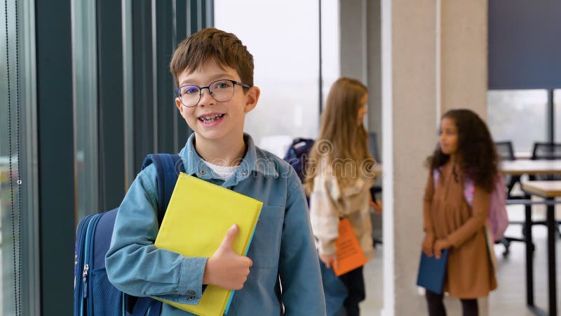 Young Elementary Schoolboy Carrying Backpack and Standing in Classroom ...
