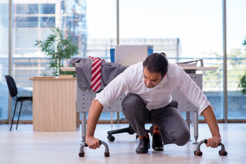 Young Male Employee Doing Sport Exercises in the Office Stock Image ...