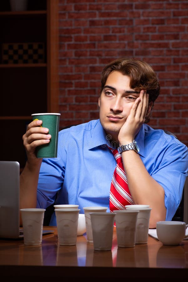 The Young Employee Drinking Coffee Working at Night Shift Stock Photo ...