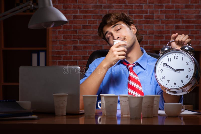 The Young Employee Drinking Coffee Working at Night Shift Stock Photo ...