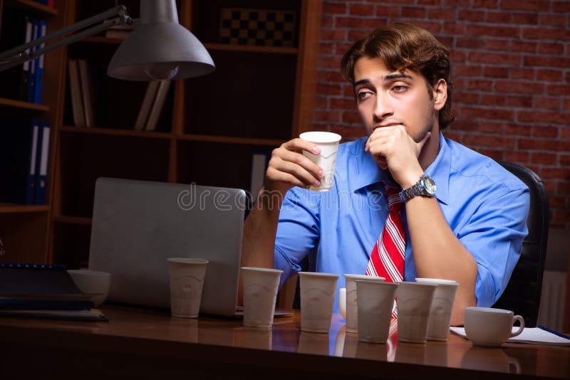 The Young Employee Drinking Coffee Working at Night Shift Stock Photo ...
