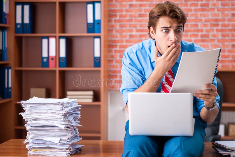 The Young Employee with Excessive Work Sitting at the Office Stock ...