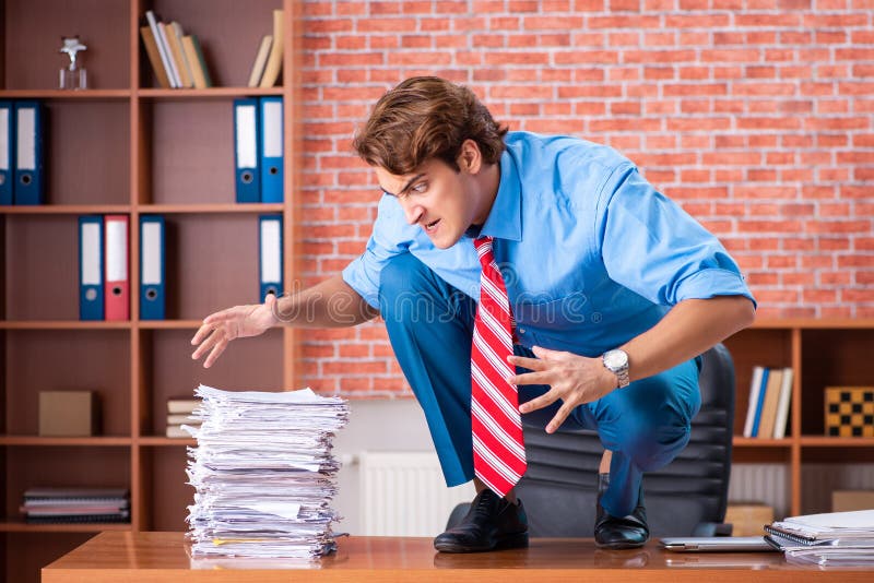The Young Employee with Excessive Work Sitting at the Office Stock ...