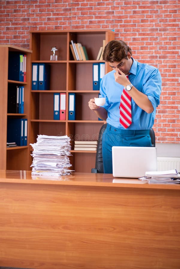 The Young Employee with Excessive Work Sitting at the Office Stock ...
