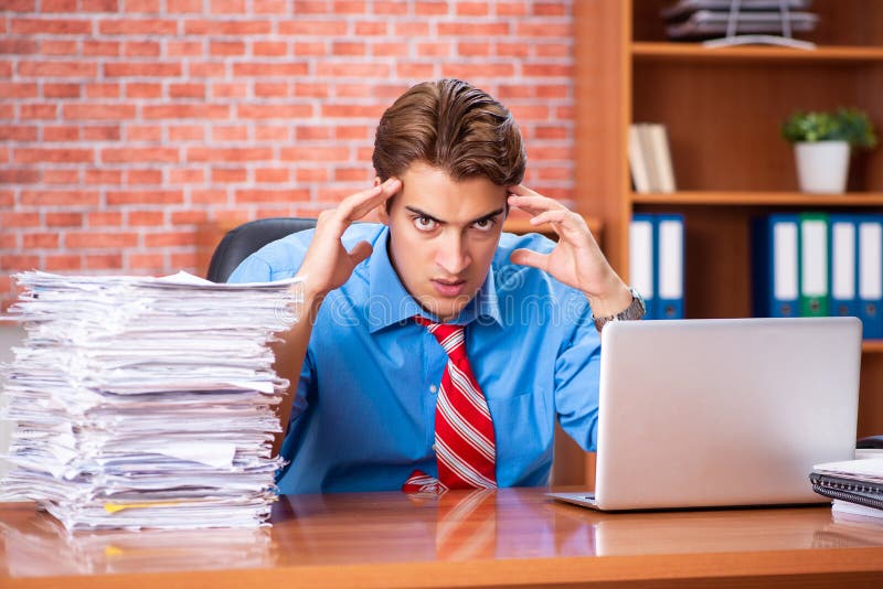 The Young Employee with Excessive Work Sitting at the Office Stock ...