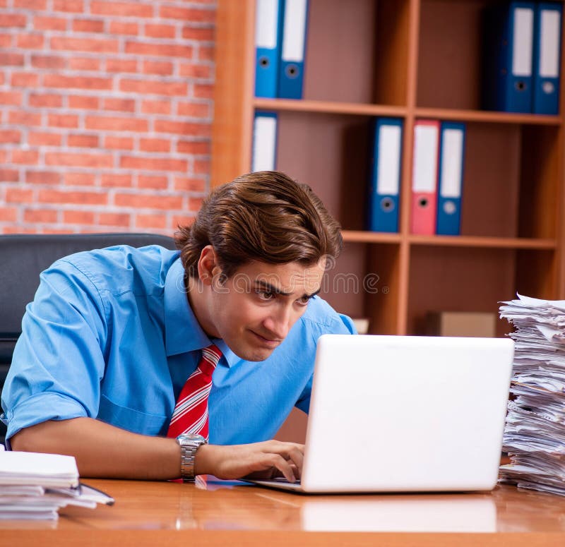 Young Employee with Excessive Work Sitting at the Office Stock Photo ...