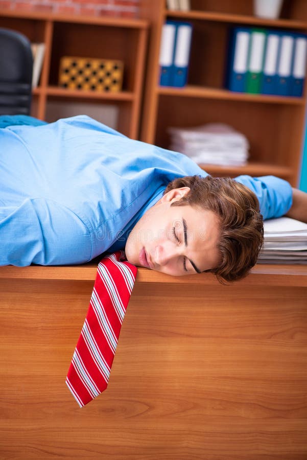 The Young Employee with Excessive Work Sitting at the Office Stock ...