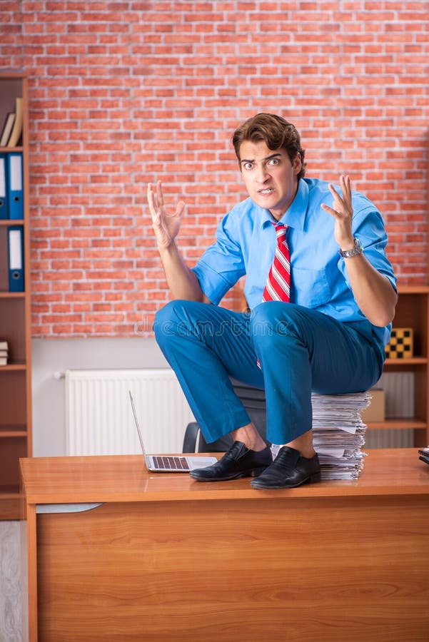The Young Employee with Excessive Work Sitting at the Office Stock ...