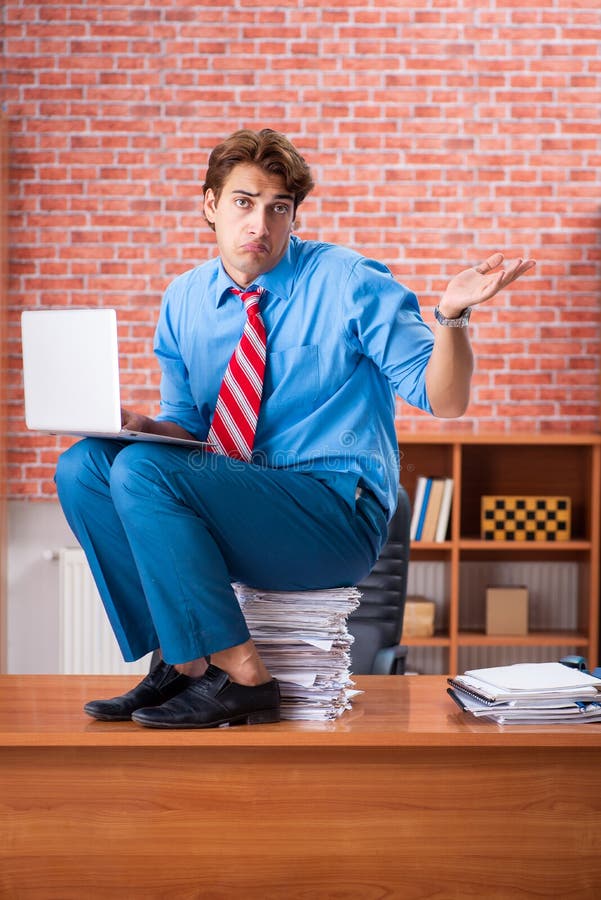 The Young Employee with Excessive Work Sitting at the Office Stock ...