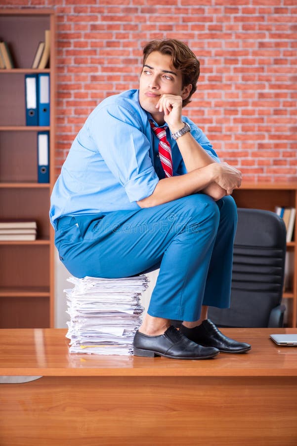 The Young Employee with Excessive Work Sitting at the Office Stock ...