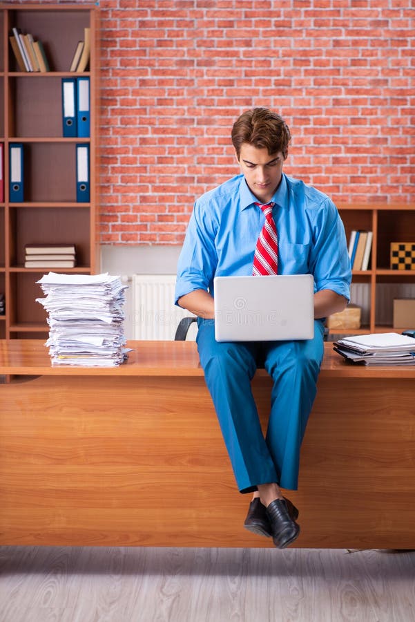 The Young Employee with Excessive Work Sitting at the Office Stock ...