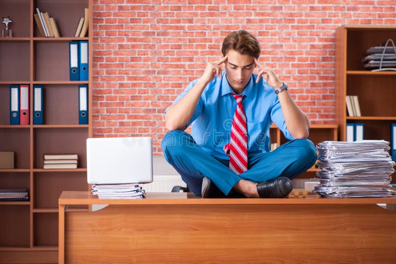 The Young Employee with Excessive Work Sitting at the Office Stock ...