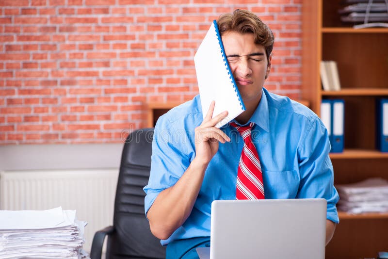 The Young Employee with Excessive Work Sitting at the Office Stock ...