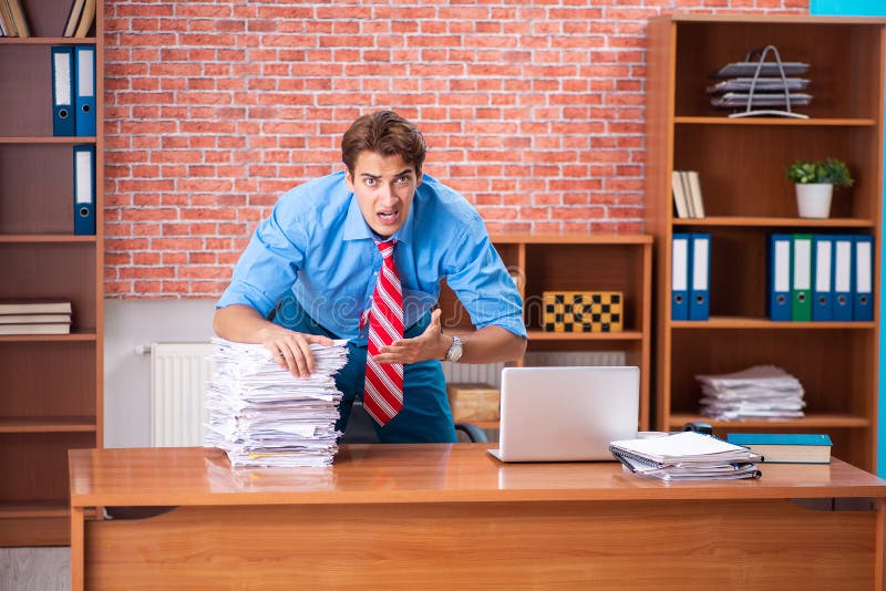 The Young Employee with Excessive Work Sitting at the Office Stock ...