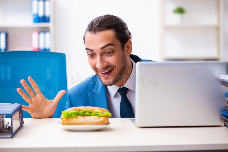 Young Male Employee Having Breakfast at Workplace Stock Photo - Image ...