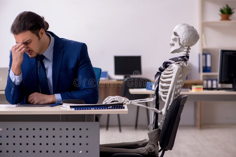Young Male Employee with Skeletons in the Office Stock Image - Image of ...