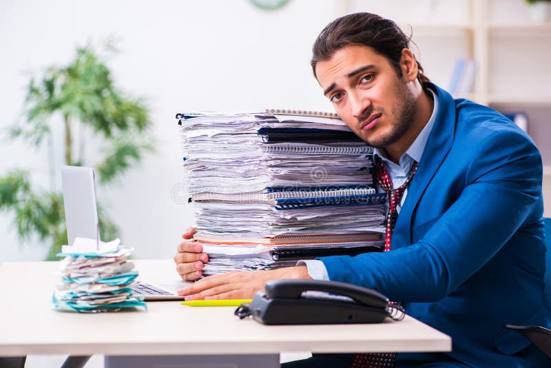 Young Male Employee Unhappy with Excessive Work Stock Photo - Image of ... Young Male Employee Unhappy with Excessive Work Stock Photo - Image of ...