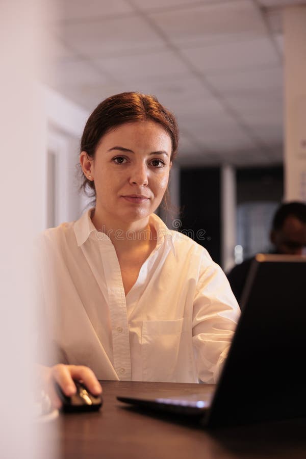Young Employee Using Laptop in Office, Looking at Camera Stock Image ...