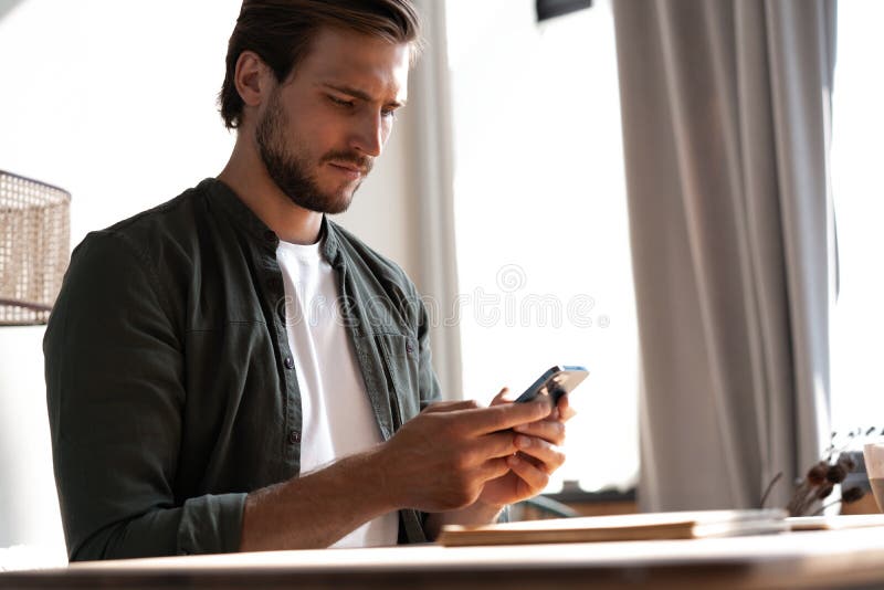 Young Employee at Workplace Using Mobile Phone, Checking Social Media ...