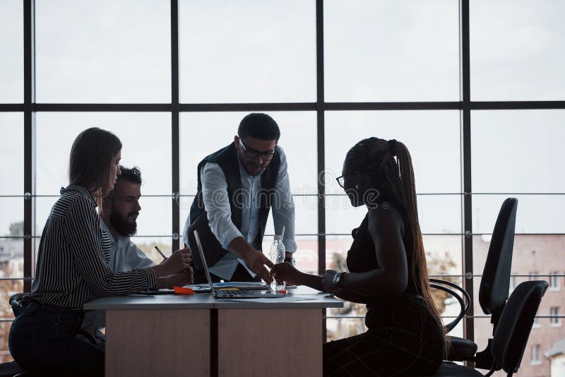 Young Employees Sitting in the Office at the Table and Using a Laptop ...