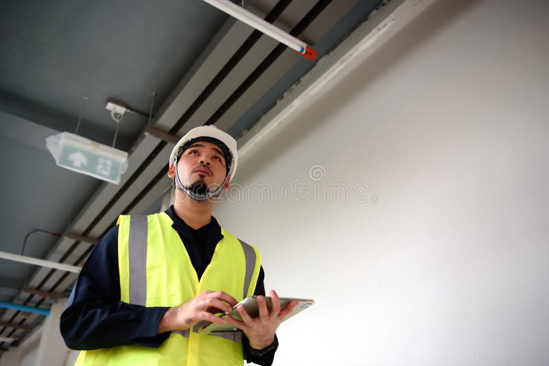 Young Engineer Apprentice Working with Technology Tablet in Survey and ...